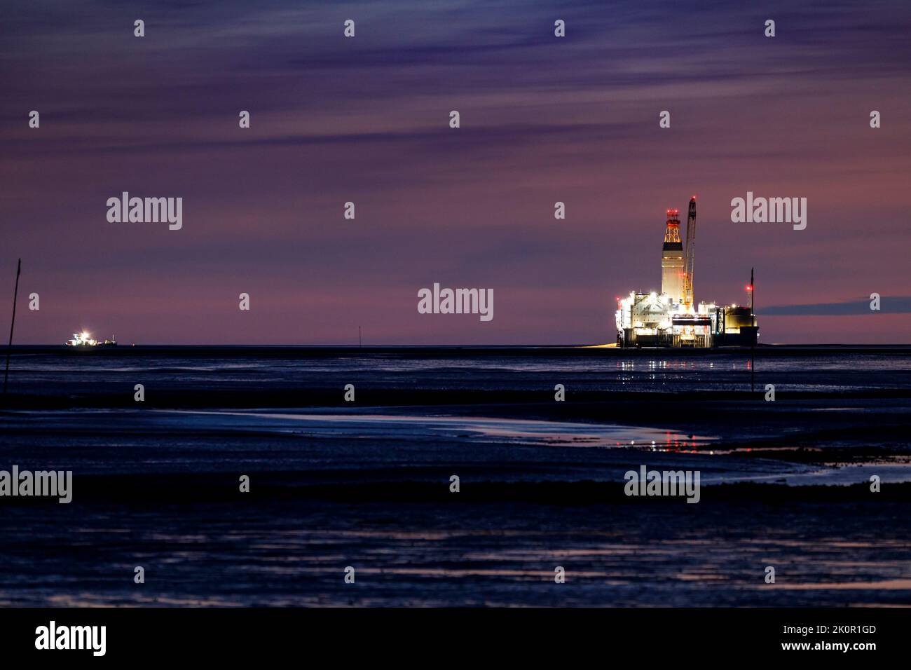 ermany's only oil rig "Mittelplate" at night and at low water, on the ...