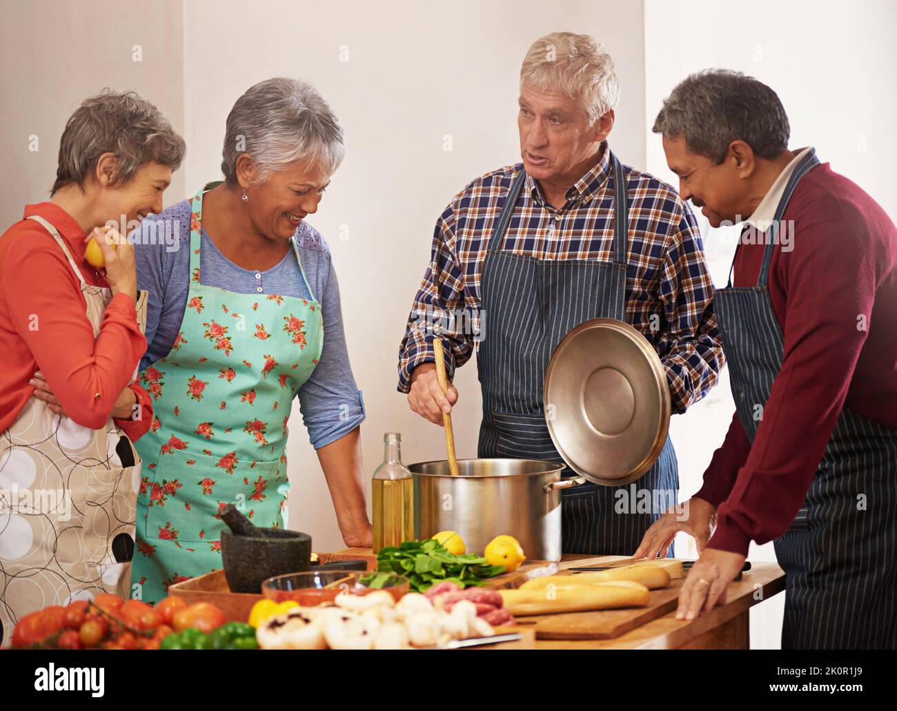 Cooking is love made visible. a group of seniors cooking in the kitchen ...
