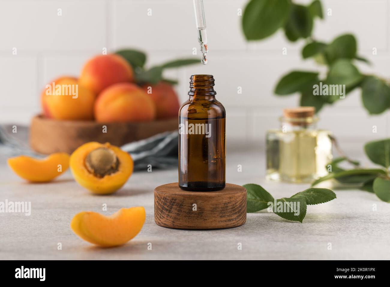 A drop of skin care serum is dripping from a pipette into a bottle. Oil ...
