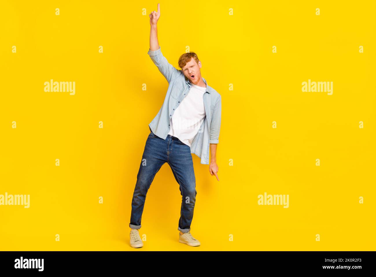 Photo of sweet cute guy dressed denim shirt dancing pointing fingers ...
