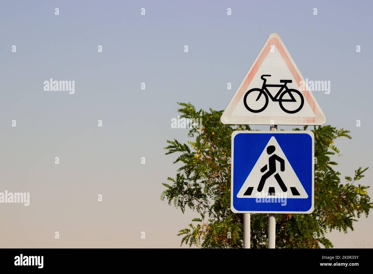 Pedestrian triangle road sign blue background Stock Photo - Alamy