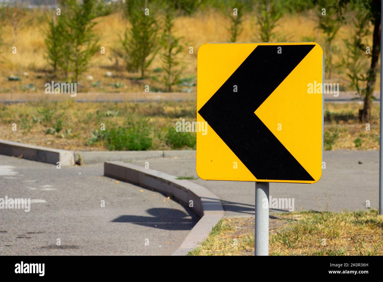 Turn road traffic direction yellow sign Stock Photo - Alamy
