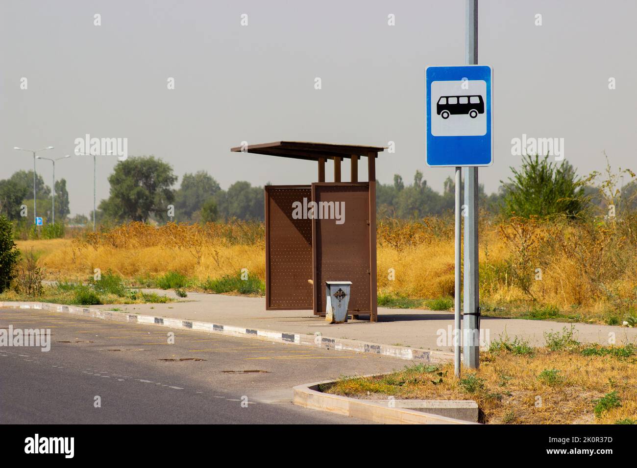 Bus stop sign on the blue background near bus station Stock Photo - Alamy
