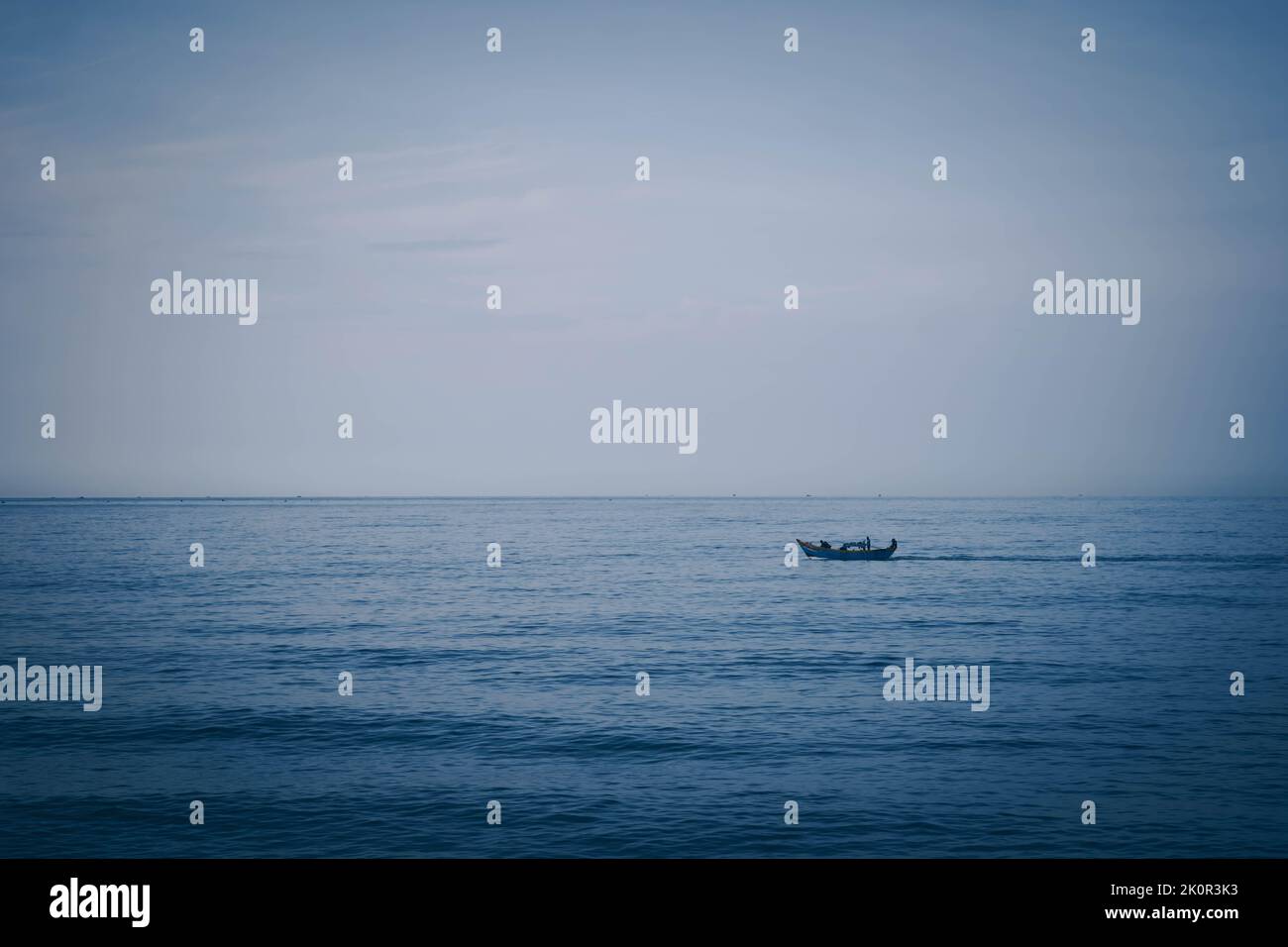 Simple background Calm dark blue sea fishing boat alone white pale ...