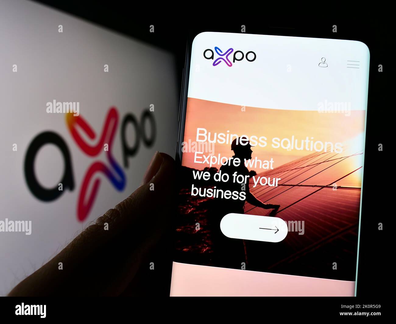 Person holding cellphone with webpage of Swiss energy company Axpo ...
