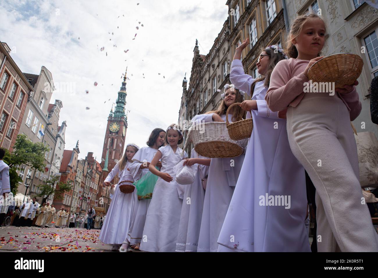Kids dressed in white dress throw flowers during the procession. Corpus ...