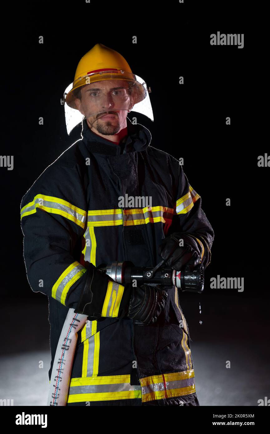 Firefighter in fire fighting operation. Portrait of a heroic fireman in ...