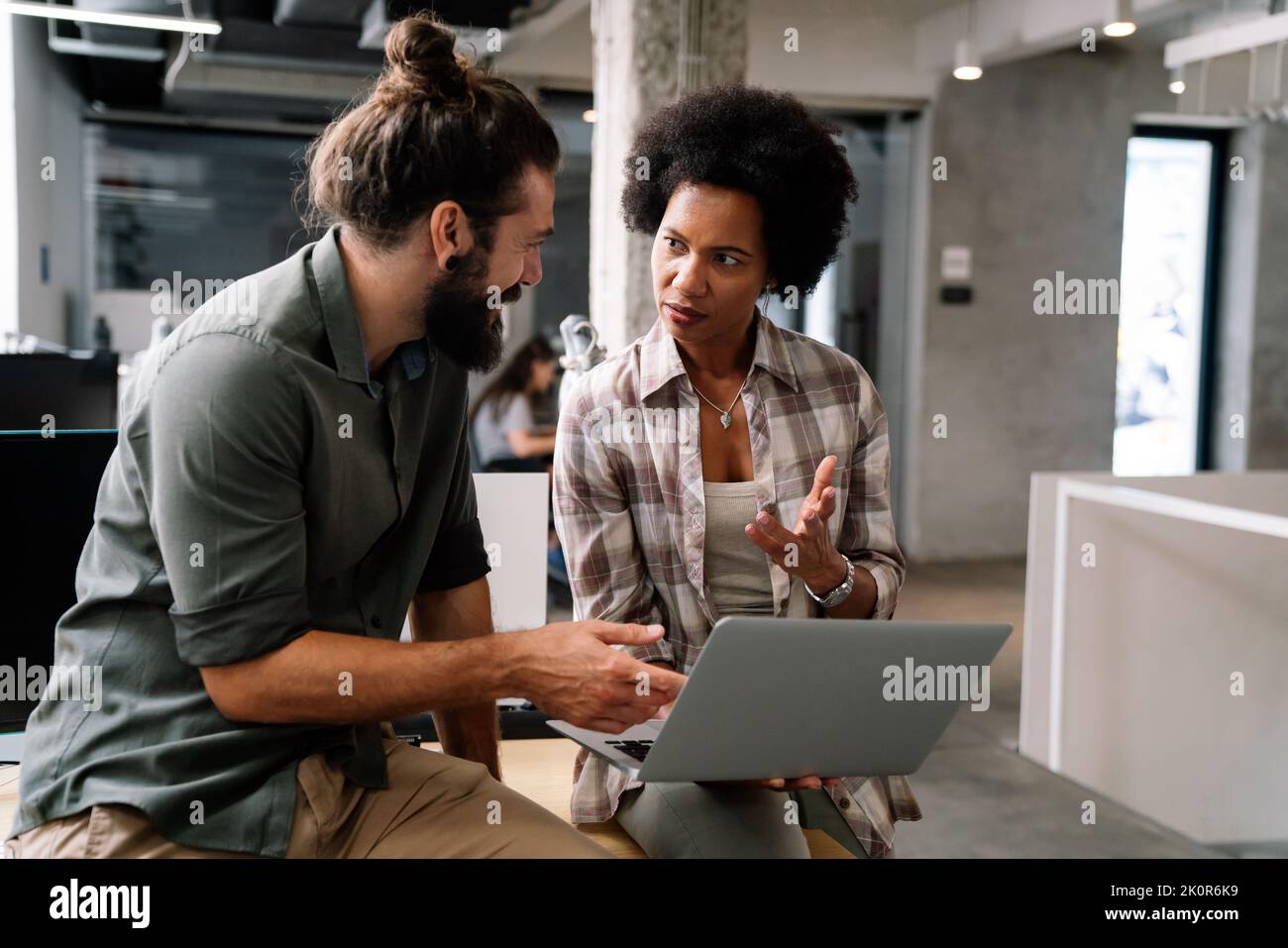 Smiling group of diverse businesspeople going over paperwork together ...