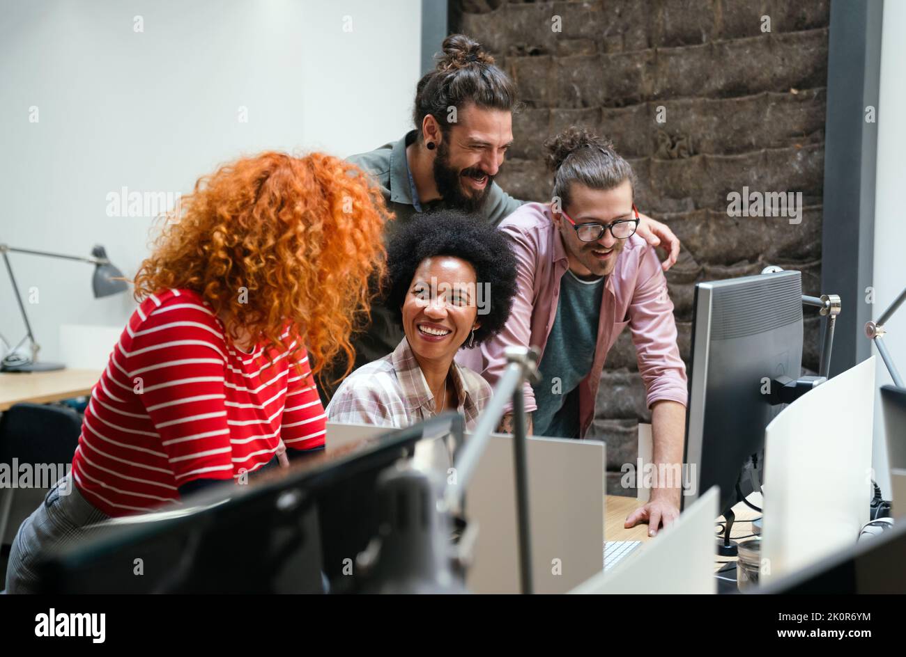 Smiling group of diverse businesspeople going over paperwork together ...