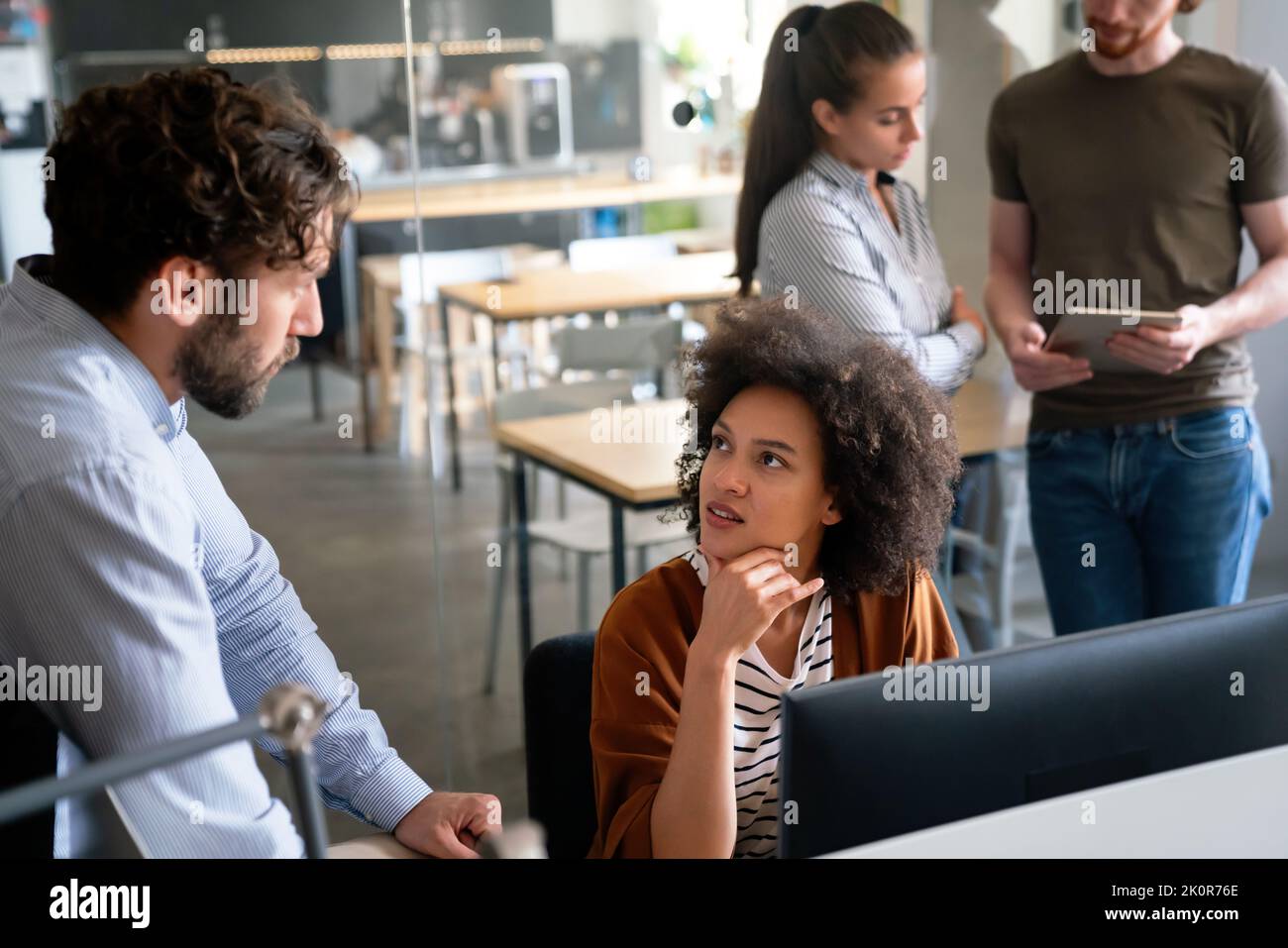 Smiling group of diverse businesspeople going over paperwork together ...