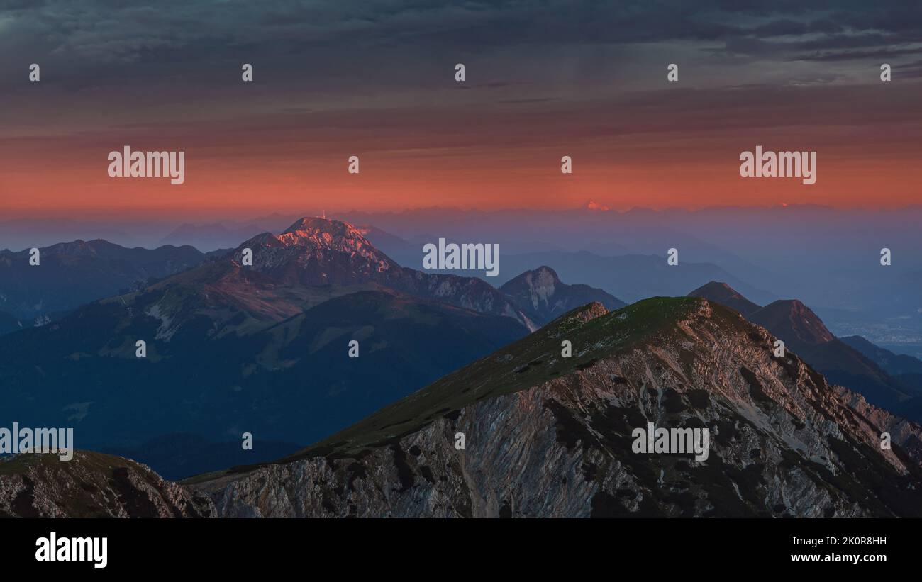 An aerial view of the beautiful mountain chain Karawanks under a pink ...