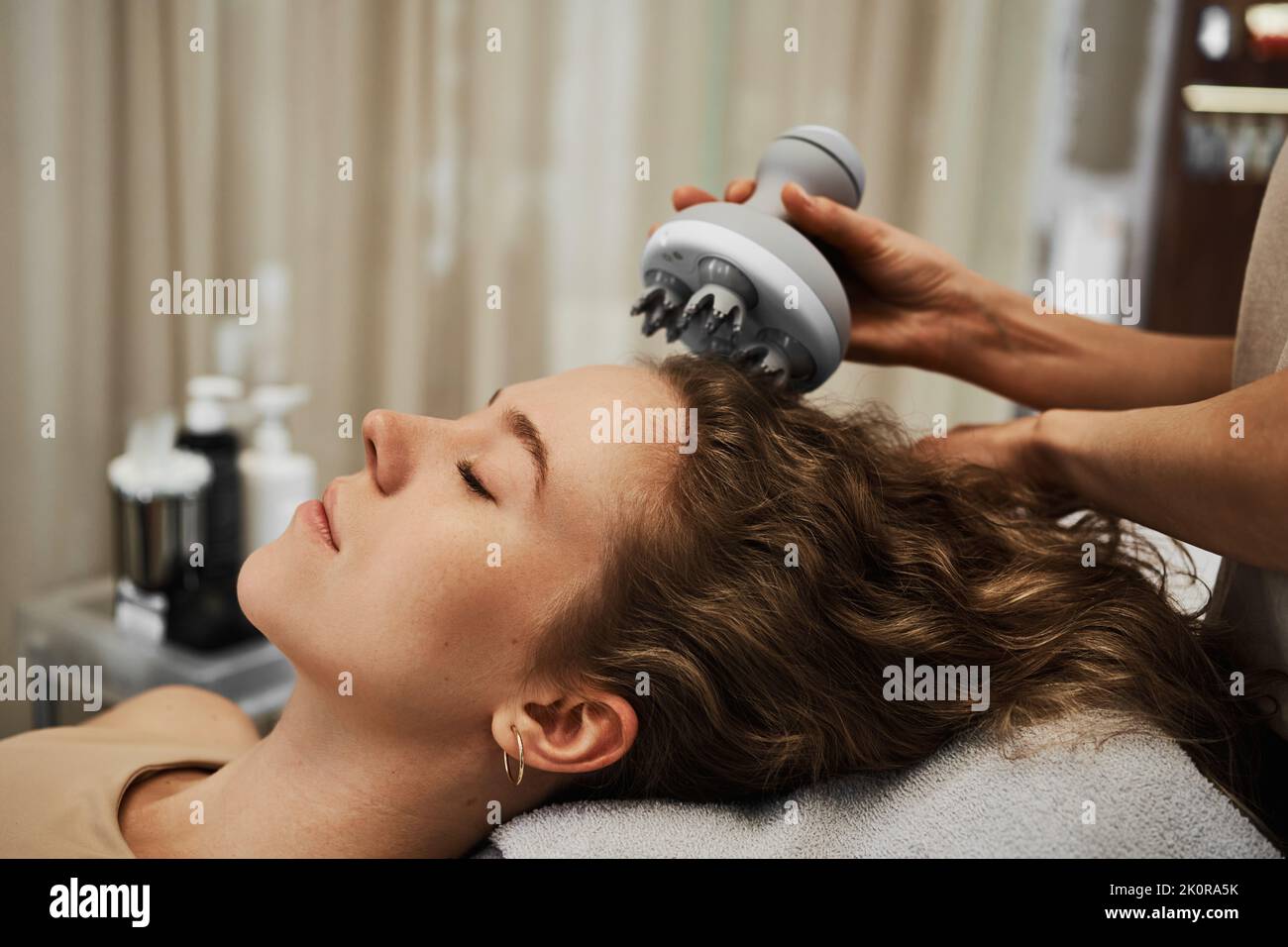 The master massages the woman's head using a gadget Stock Photo - Alamy