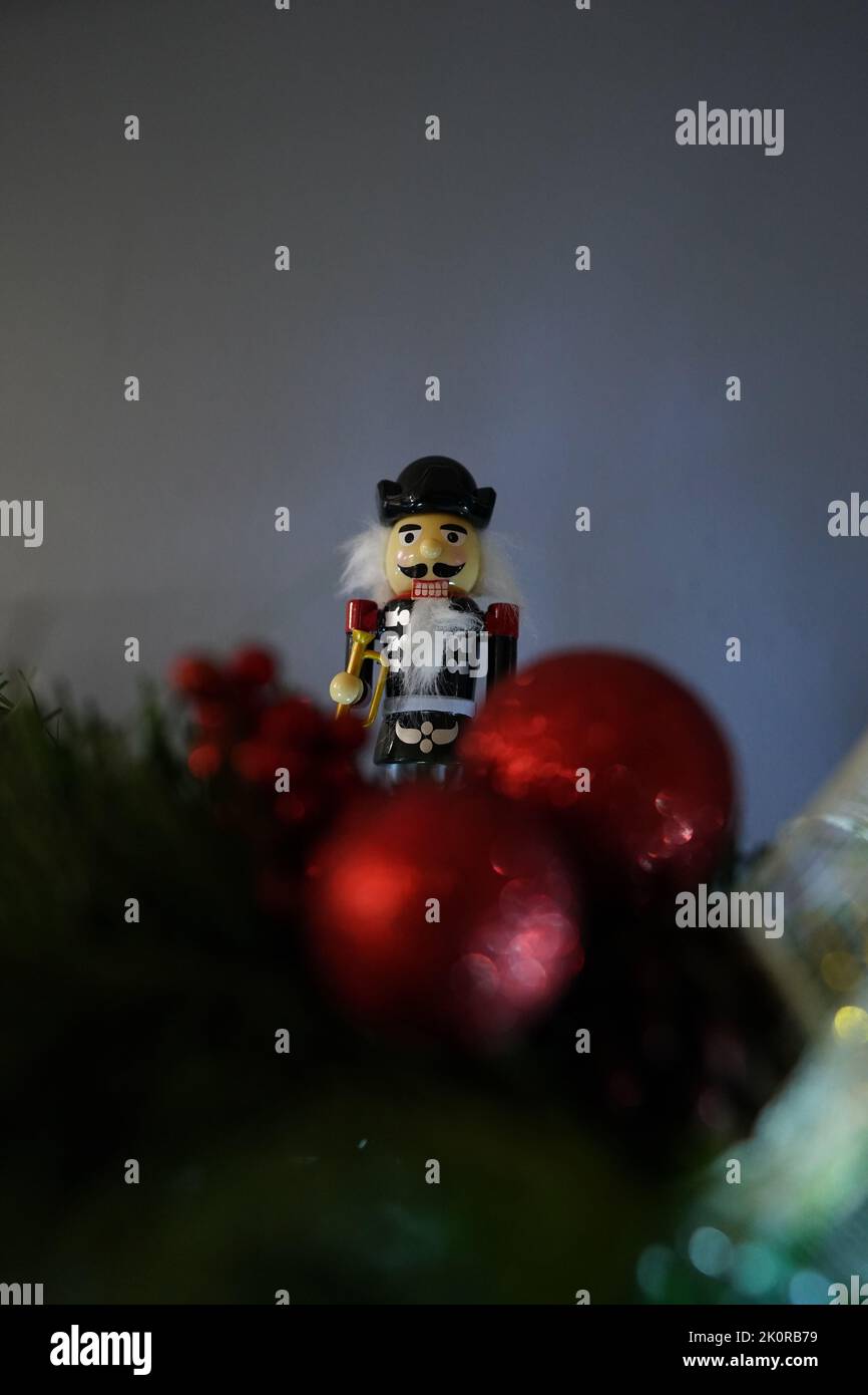 A nutcracker toy on top of the Christmas tree with colorful balls Stock ...