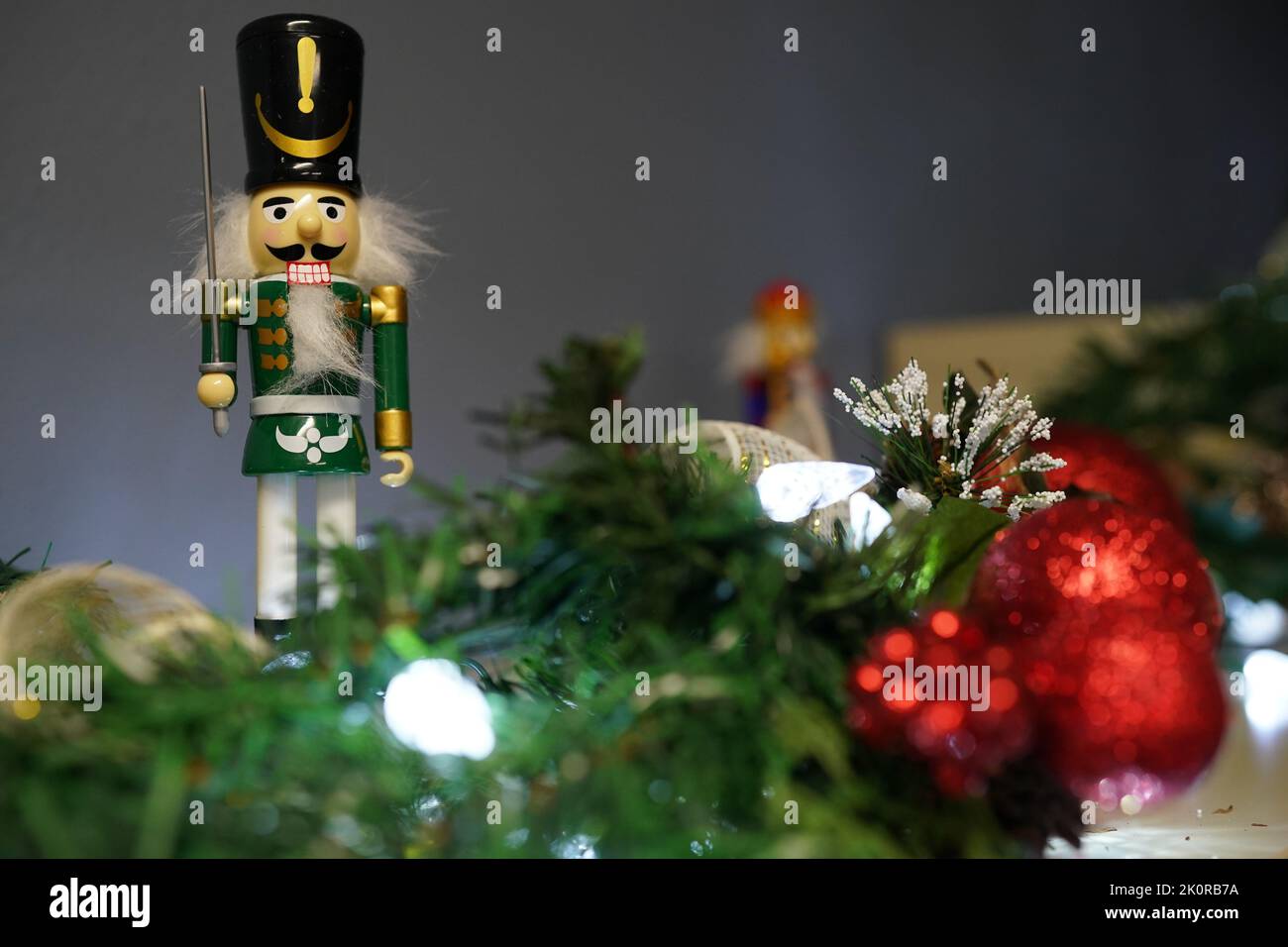 A nutcracker toy on top of the Christmas tree with colorful balls Stock ...