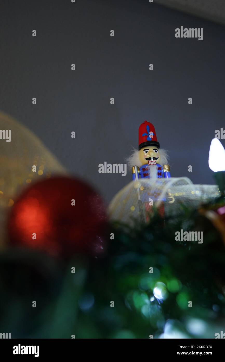 A nutcracker toy on top of the Christmas tree with colorful balls Stock ...
