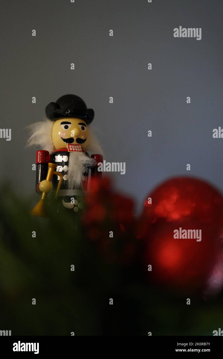 A nutcracker toy on top of the Christmas tree with colorful balls Stock ...