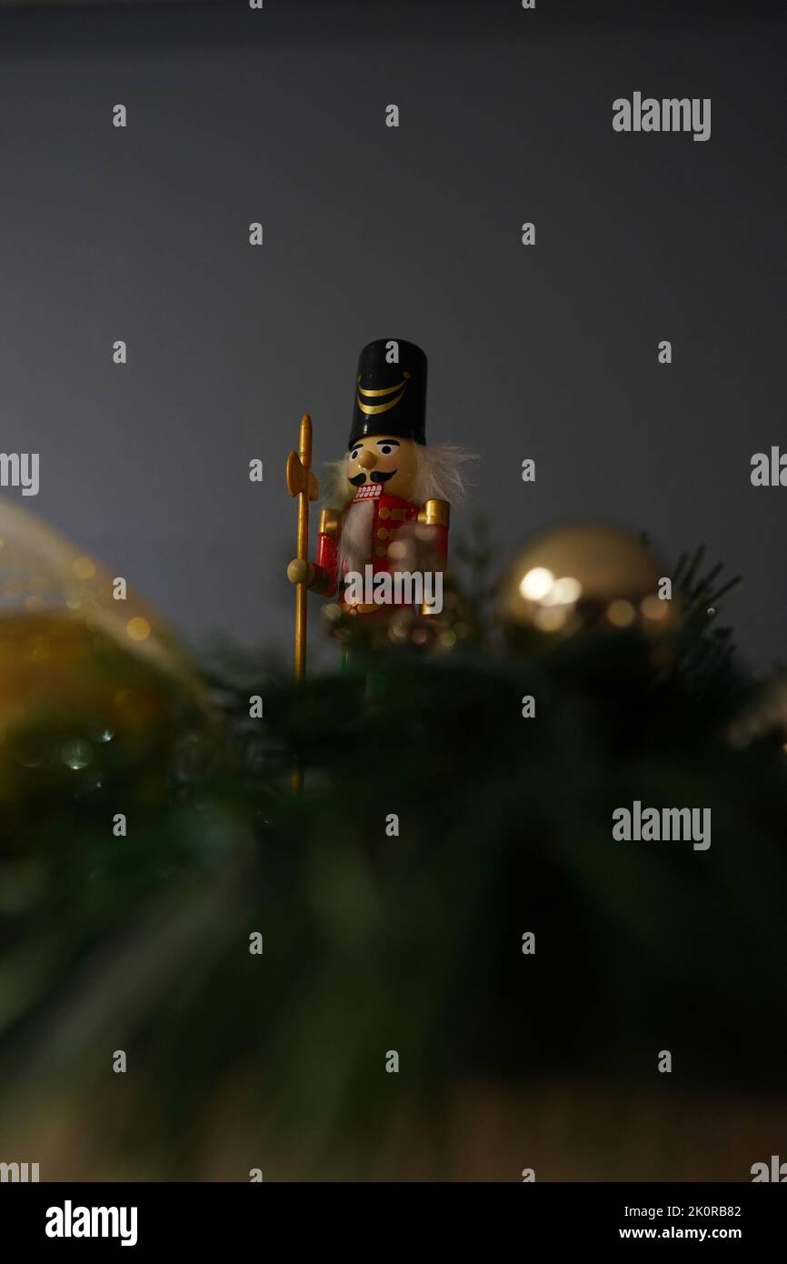 A nutcracker toy on top of the Christmas tree with colorful balls Stock ...