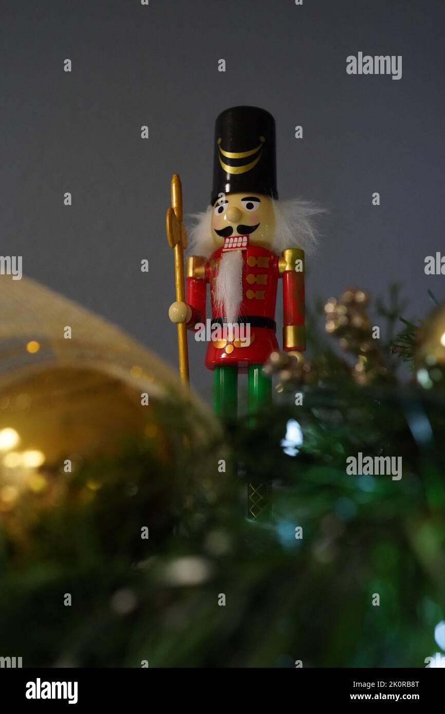A nutcracker toy on top of the Christmas tree with colorful balls Stock ...