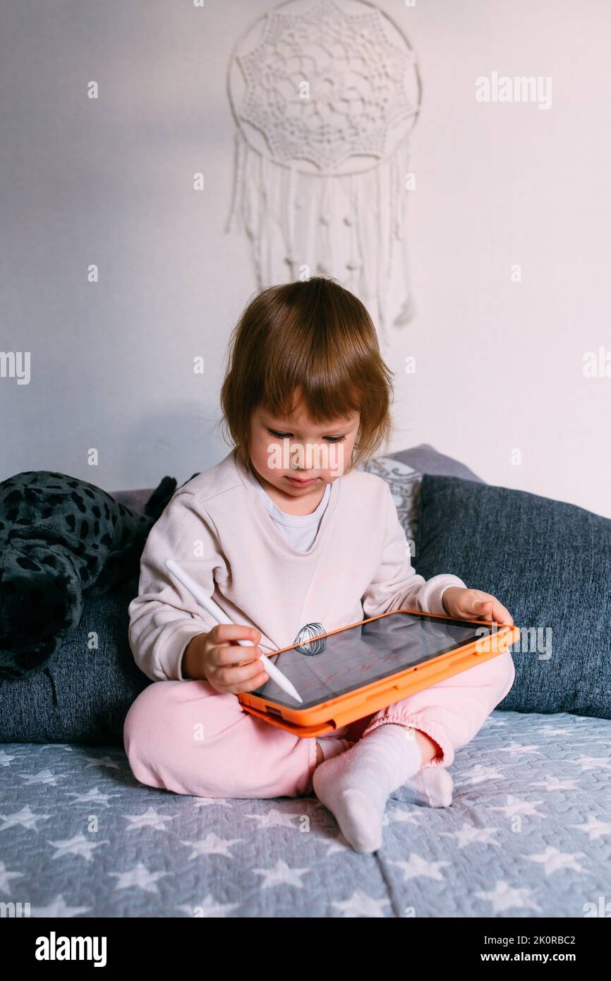 Child using technology. Toddler at home with a tablet and a pen stylus ...