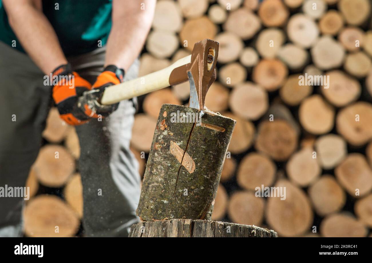Hand and axe in firewood, chopping wood for fire heat Stock Photo - Alamy