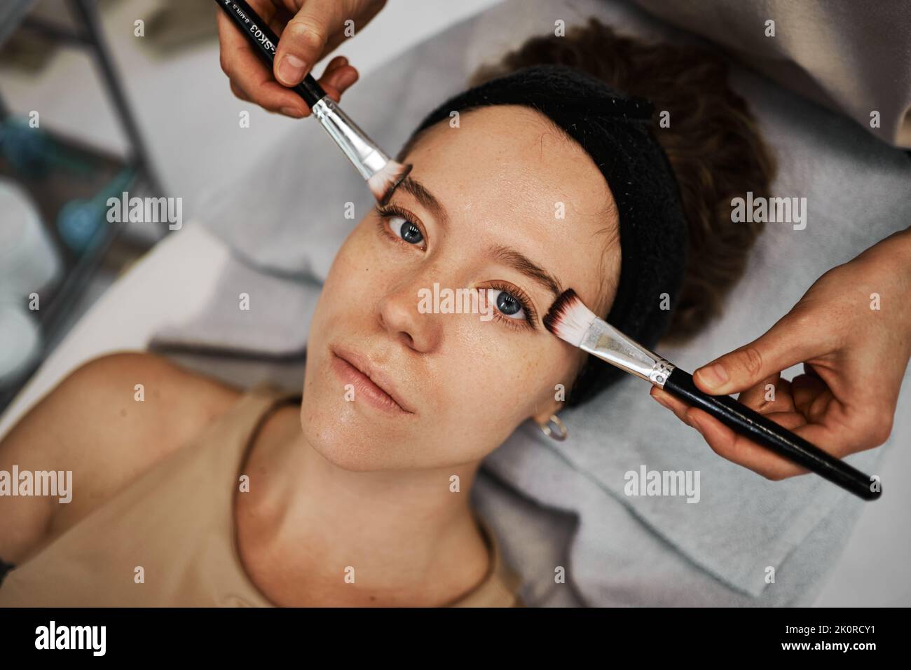 A smear of cream on the face of a young woman. Brush massage Stock ...