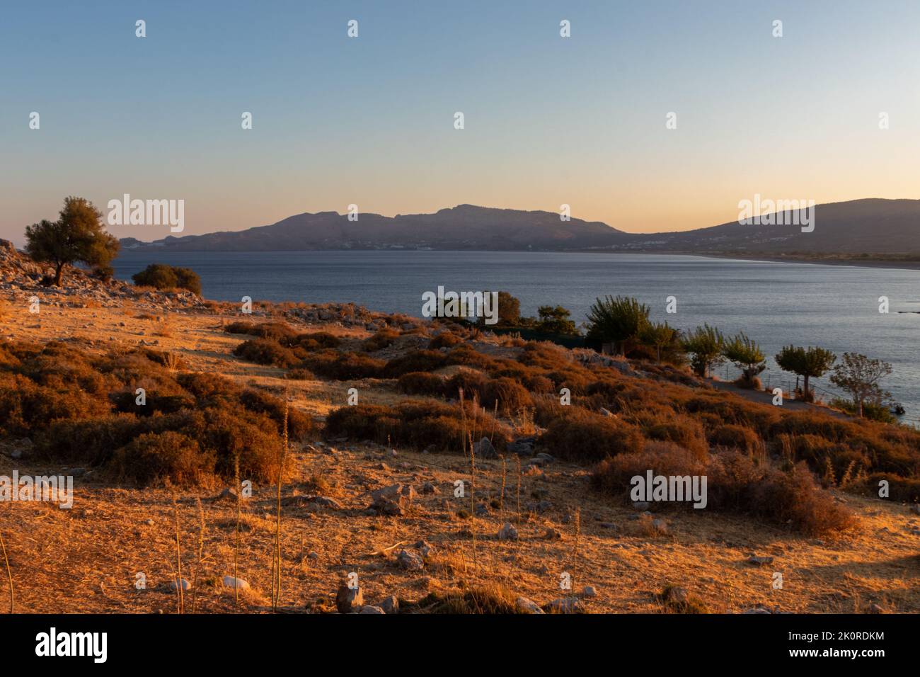 A beautiful scenery of a blue lake surrounded by hills at sunset in a ...
