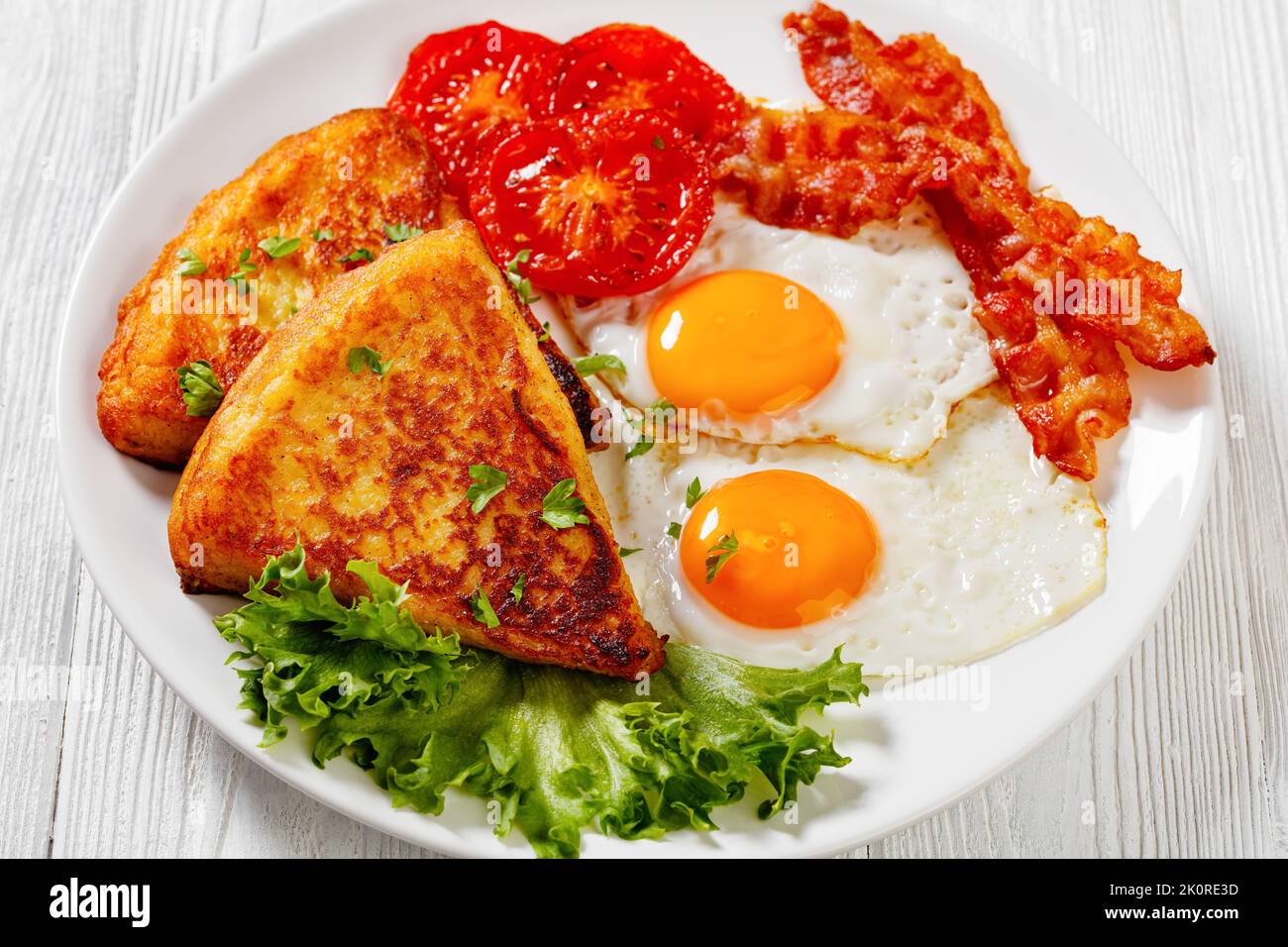close-up of fried eggs, rasher or bacon slices, fried potato bread ...