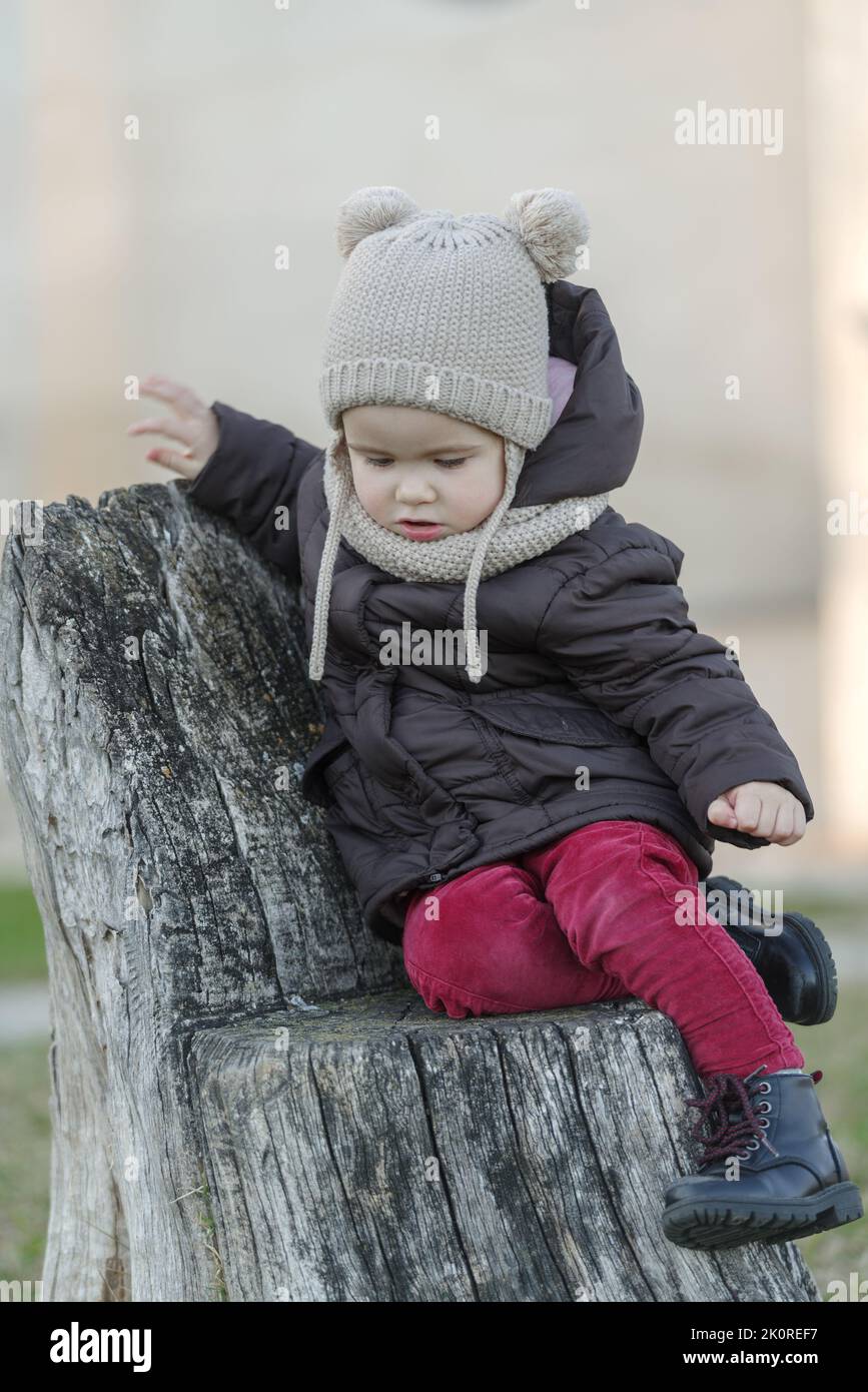 Baby girl sitting on stump hi-res stock photography and images - Alamy