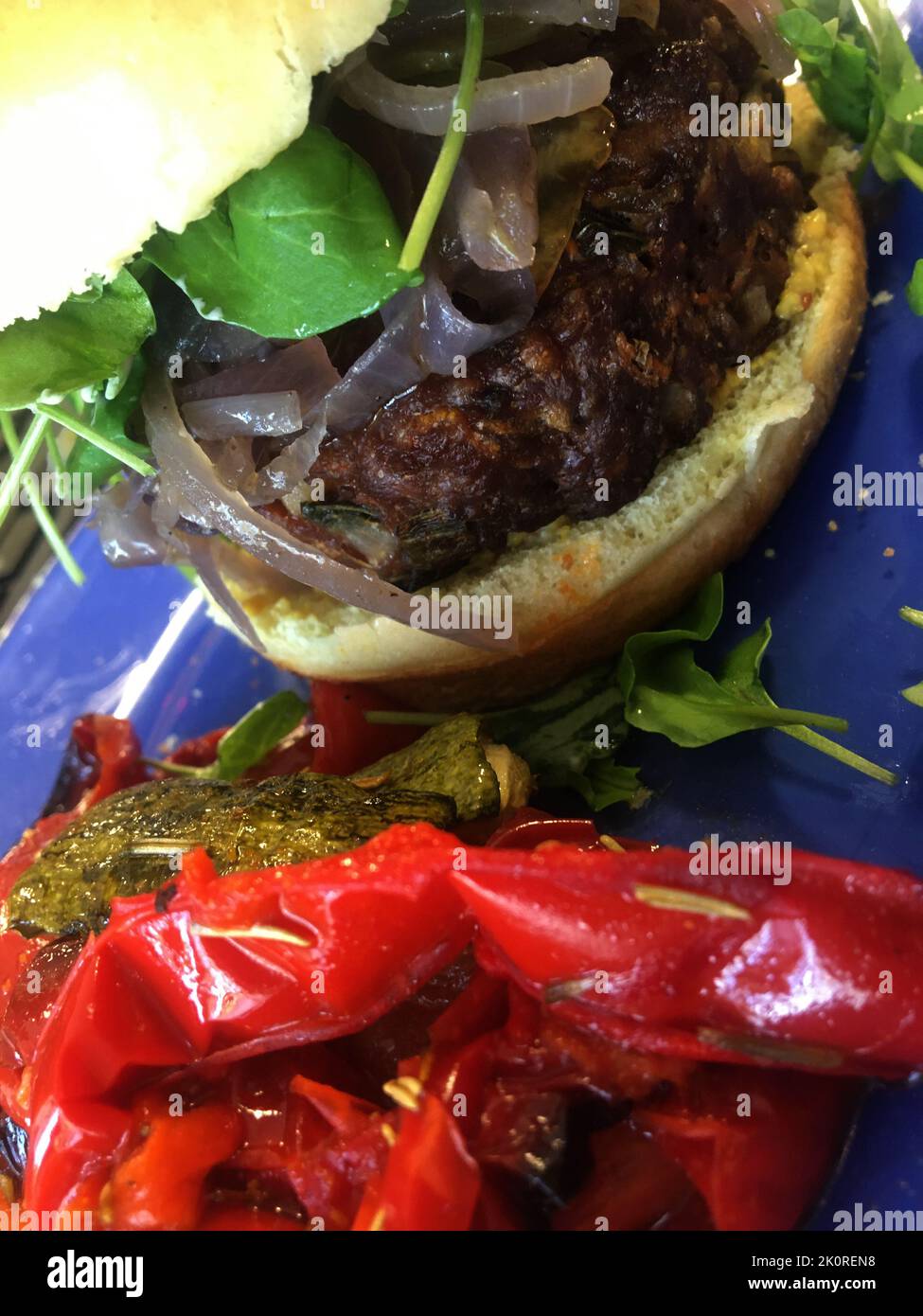Gourmet Burger on Blue Plate with Roasted Peppers Stock Photo - Alamy