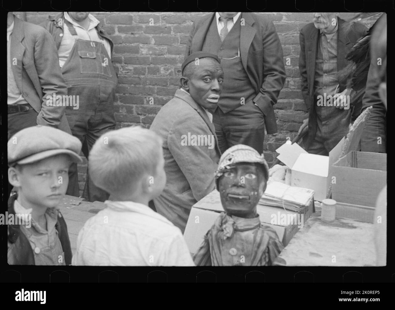African-American performer wearing partial blackface makeup sits on a ...