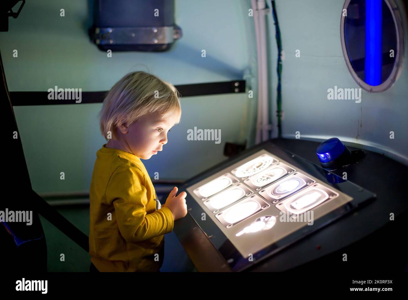 Little toddler boy in a space ship, illuminated control panel, child as ...