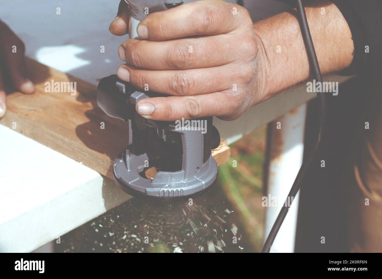 closeup of carpenter with hand wood router machine at work. closeup of ...
