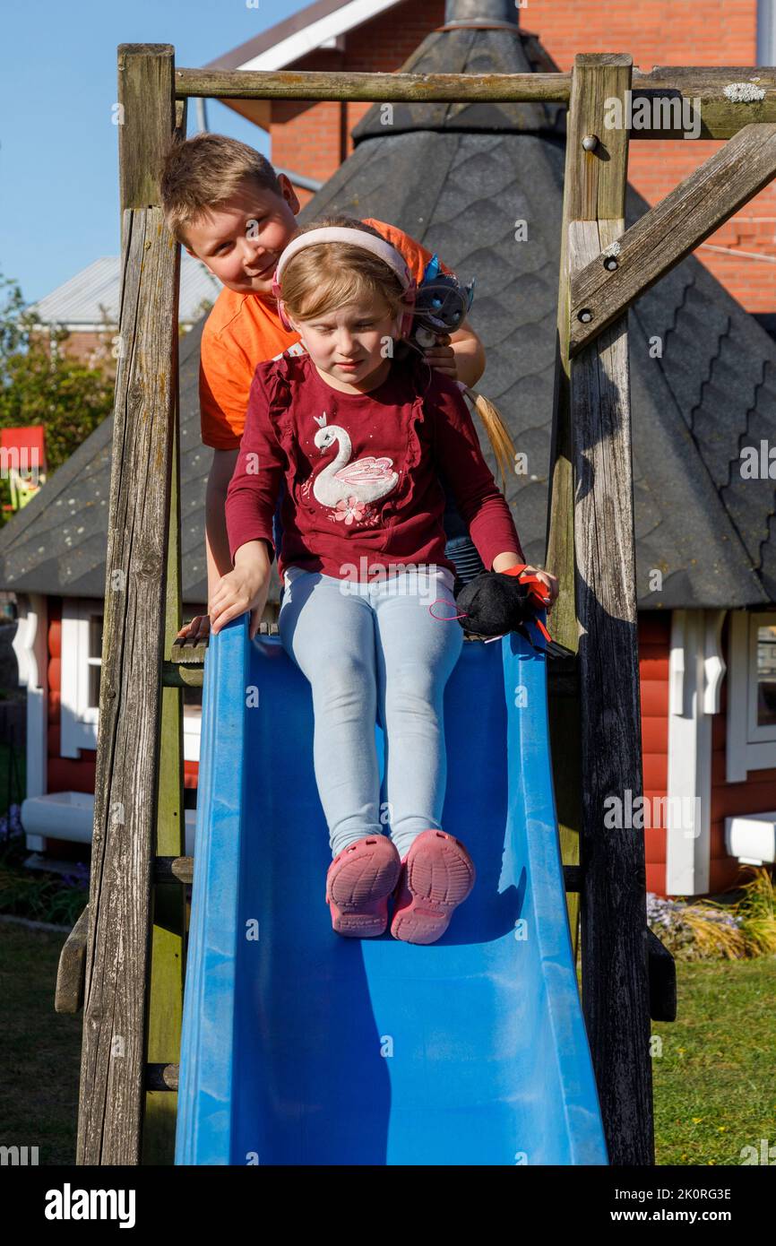 Siblings on the slide Stock Photo - Alamy