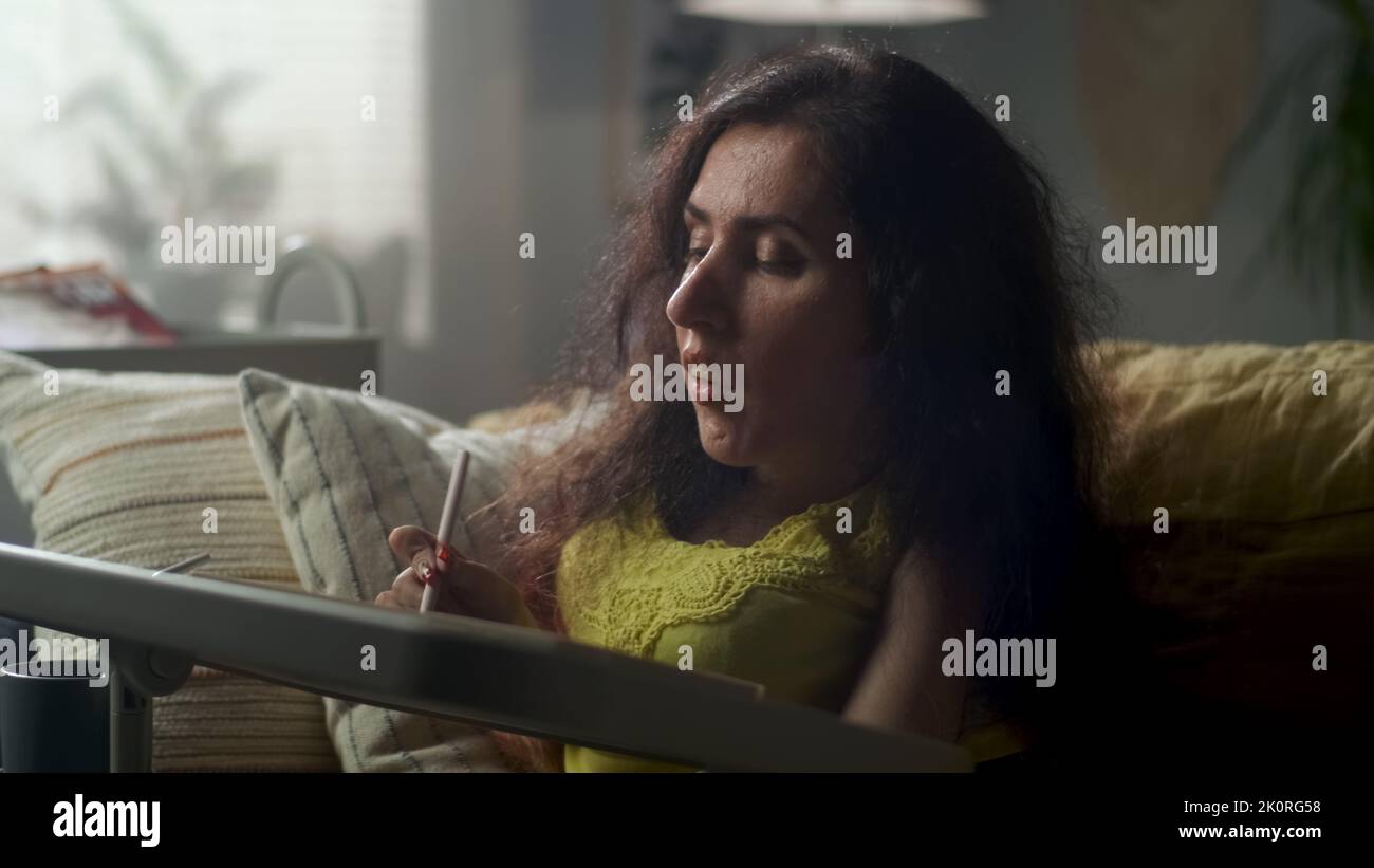 Concentrated woman with spinal muscular atrophy sitting on a couch at ...