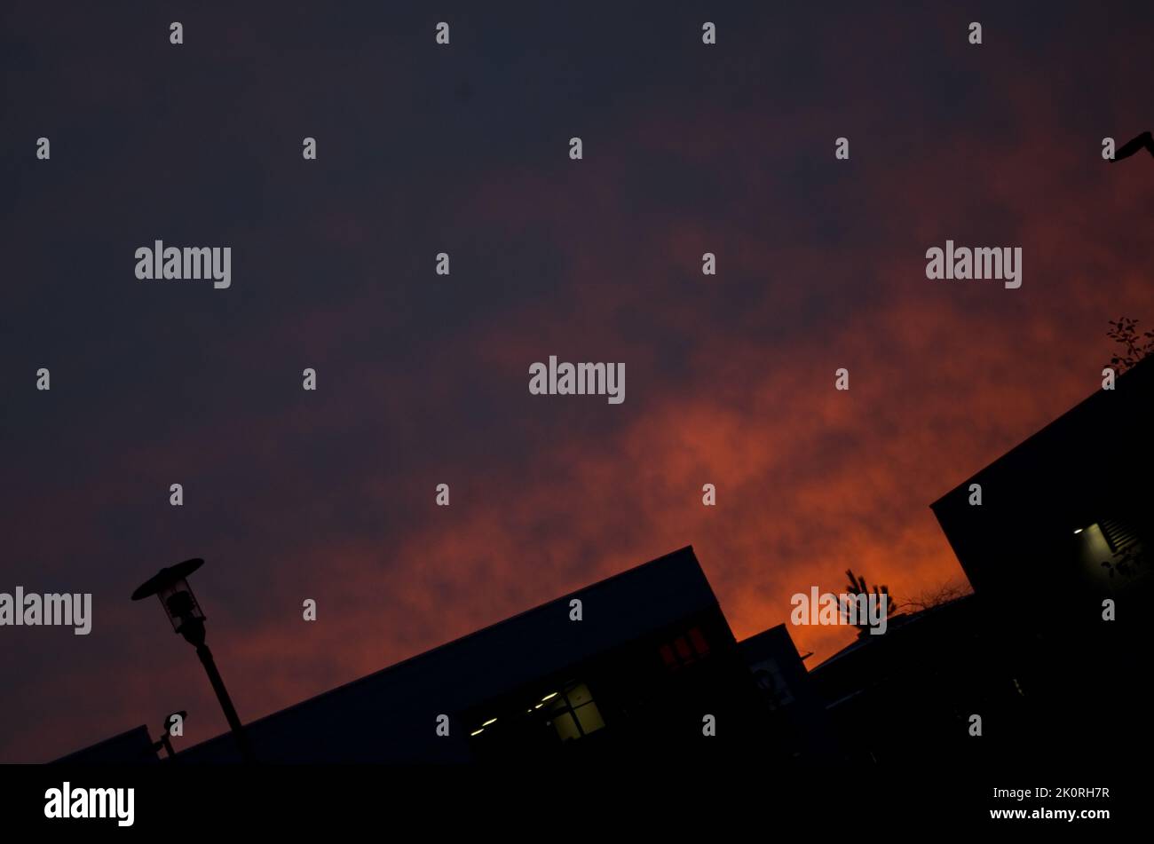 Fiery sunset over industrial silhouette. Angled horizon Stock Photo - Alamy
