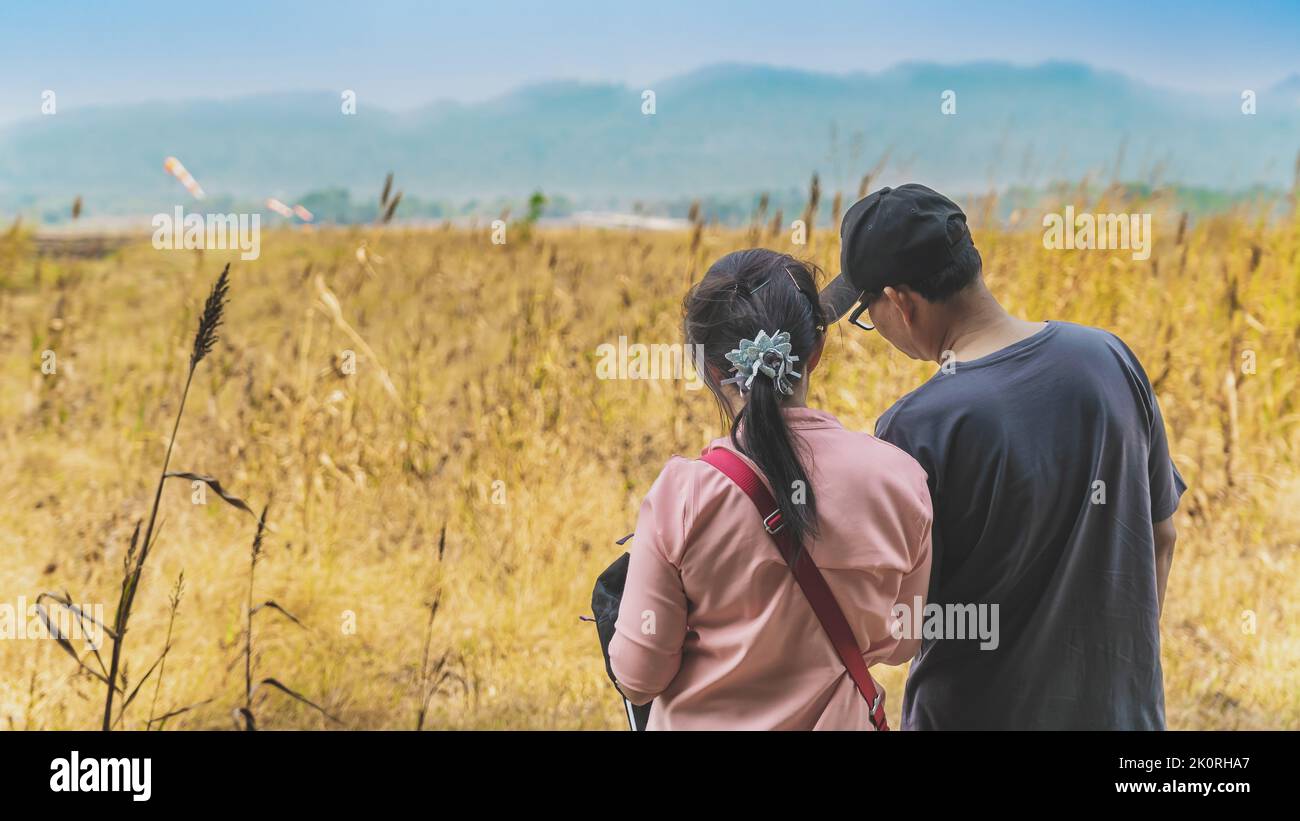 Back view of Asian couple farmers using mobile phone for farming in ...