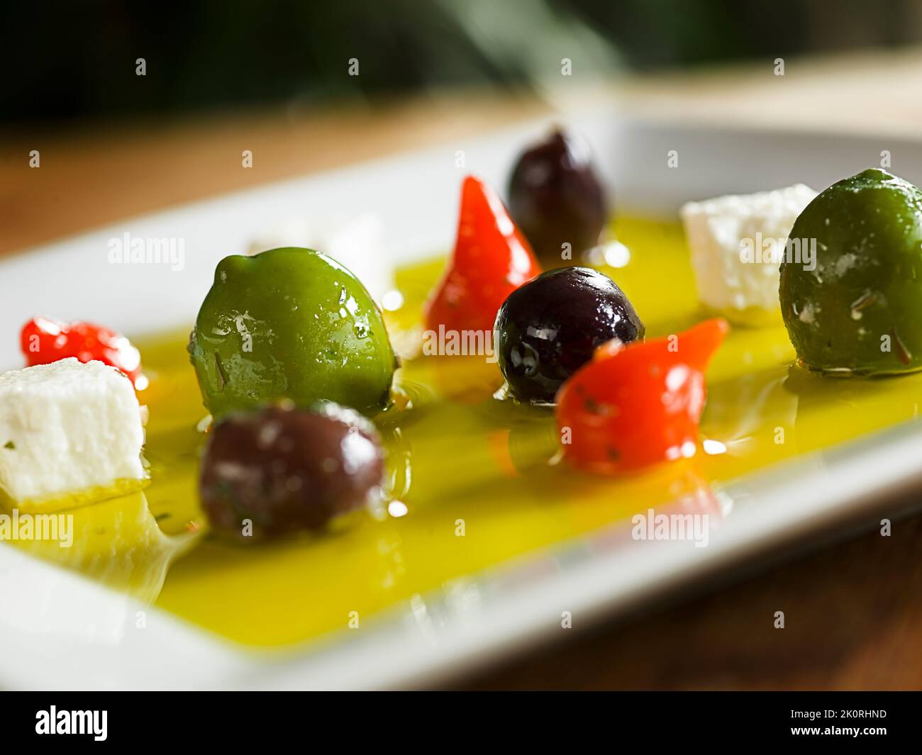 Studio images of side dishes including olives, oil, nuts and peppers ...