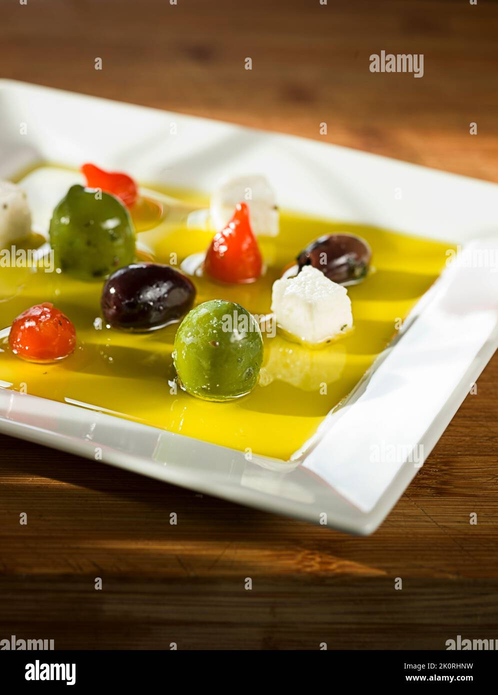 Studio images of side dishes including olives, oil, nuts and peppers ...