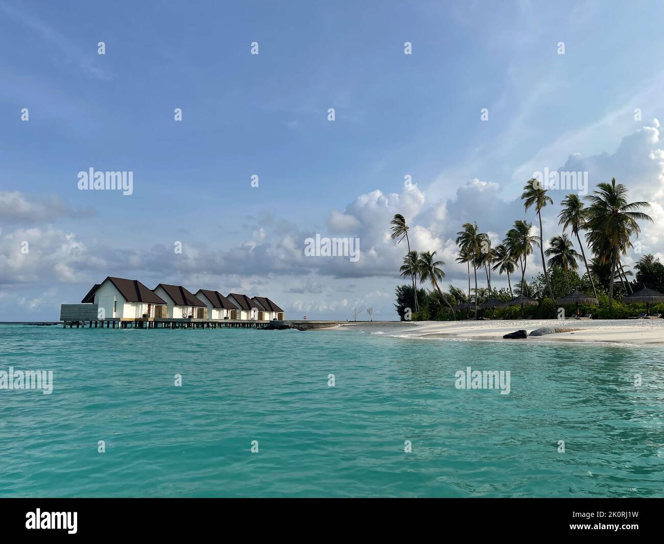 Beautiful views of a tropical island with water villas in the distance ...