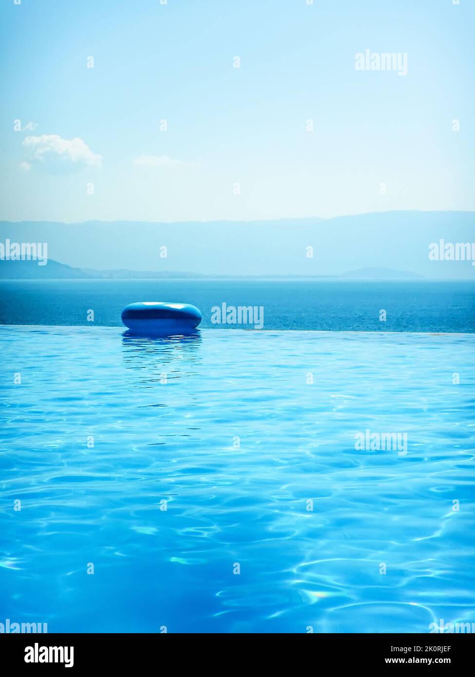 Infinity swimming pool with sea and Mountain View, blue float Stock ...