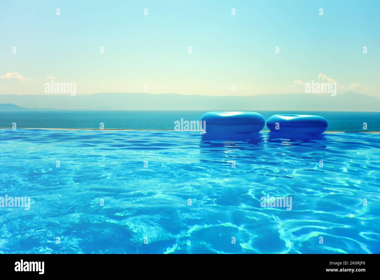 Infinity swimming pool with sea and Mountain View, blue float Stock ...