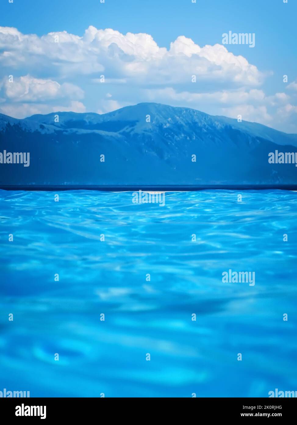 Infinity swimming pool with sea and Mountain View Stock Photo - Alamy