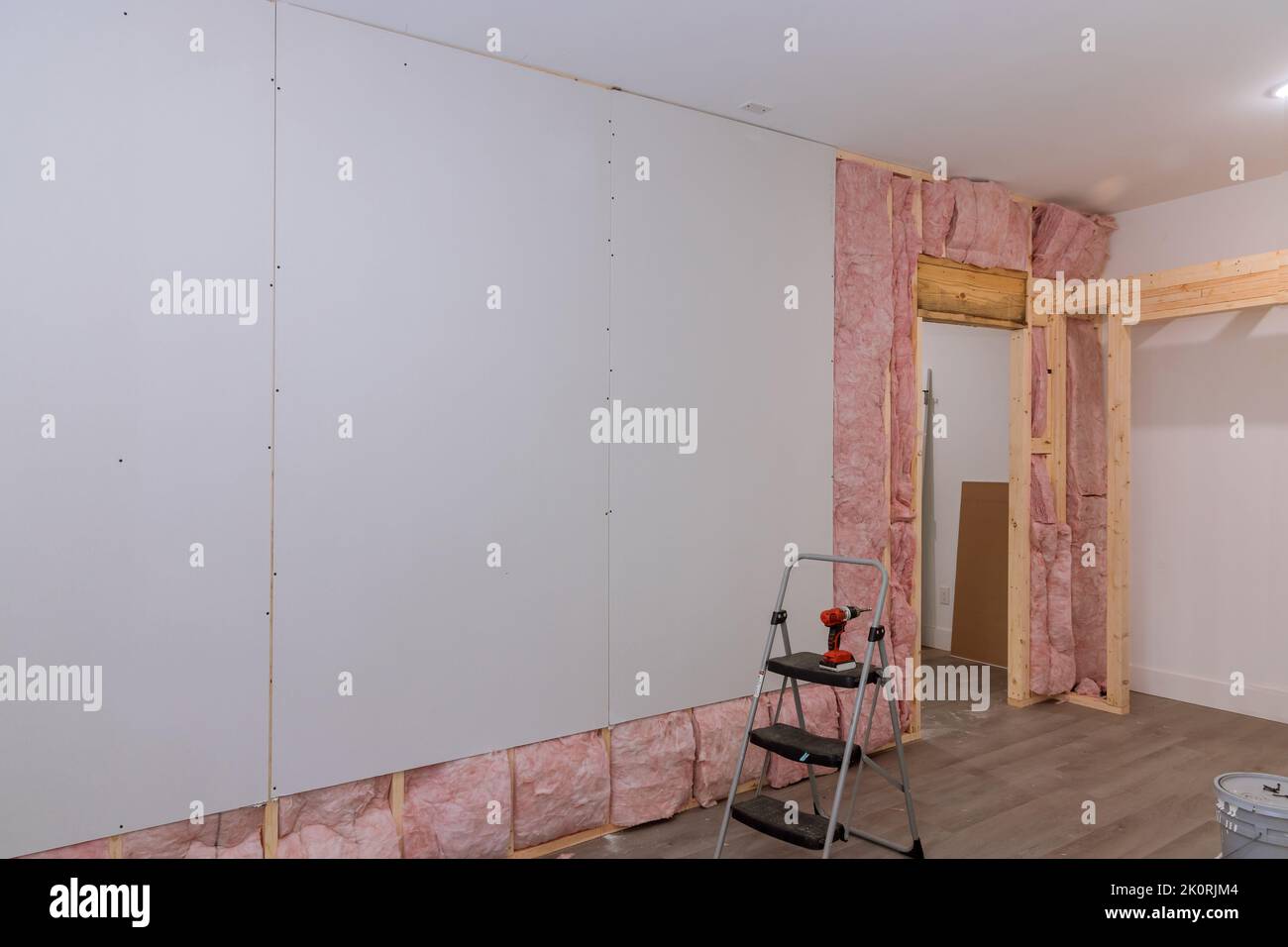 The drywall is screwed to the beams framing of the wall after sound and ...
