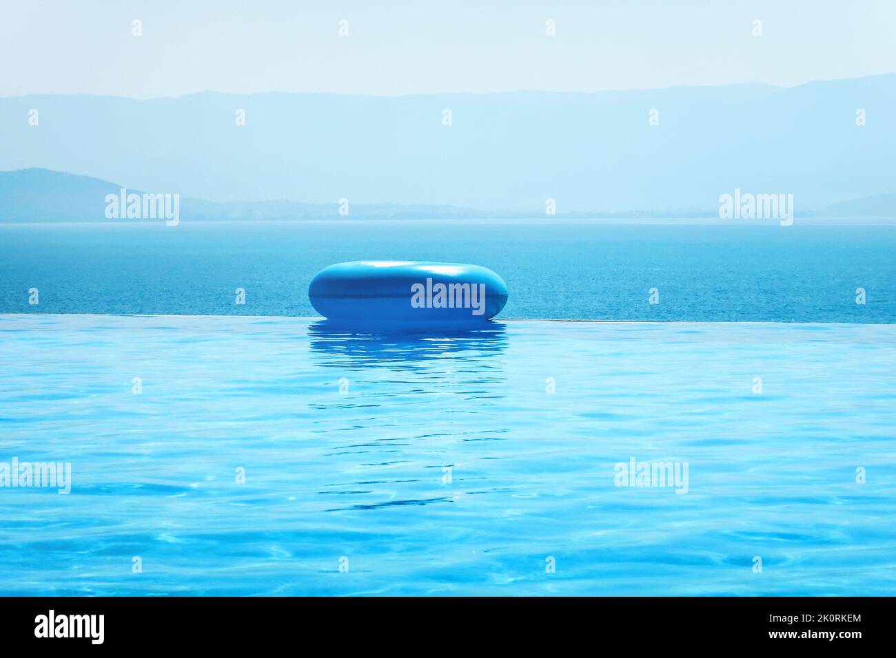 Infinity swimming pool with sea and Mountain View, blue float Stock ...