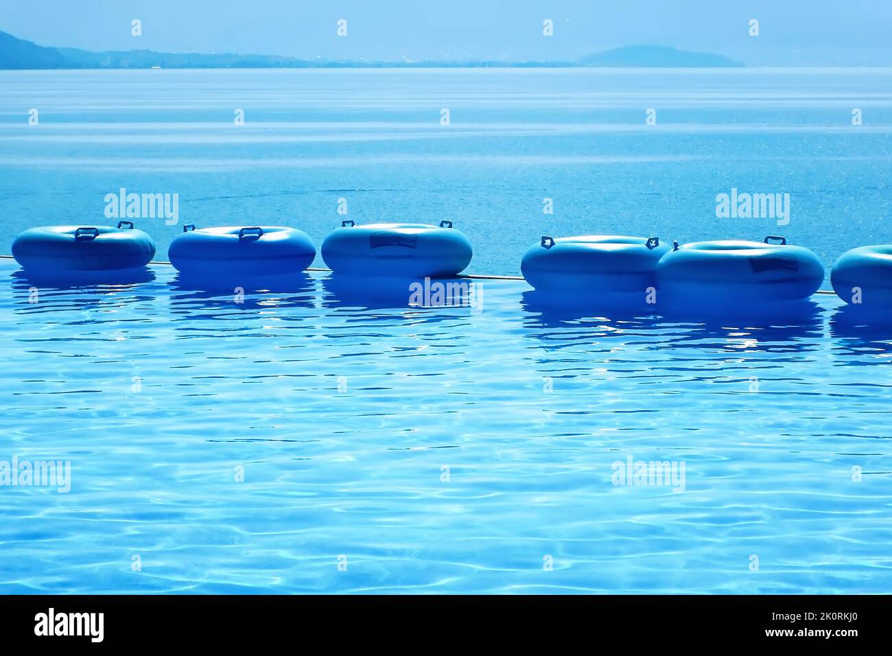 Infinity swimming pool with sea and Mountain View, blue float Stock ...
