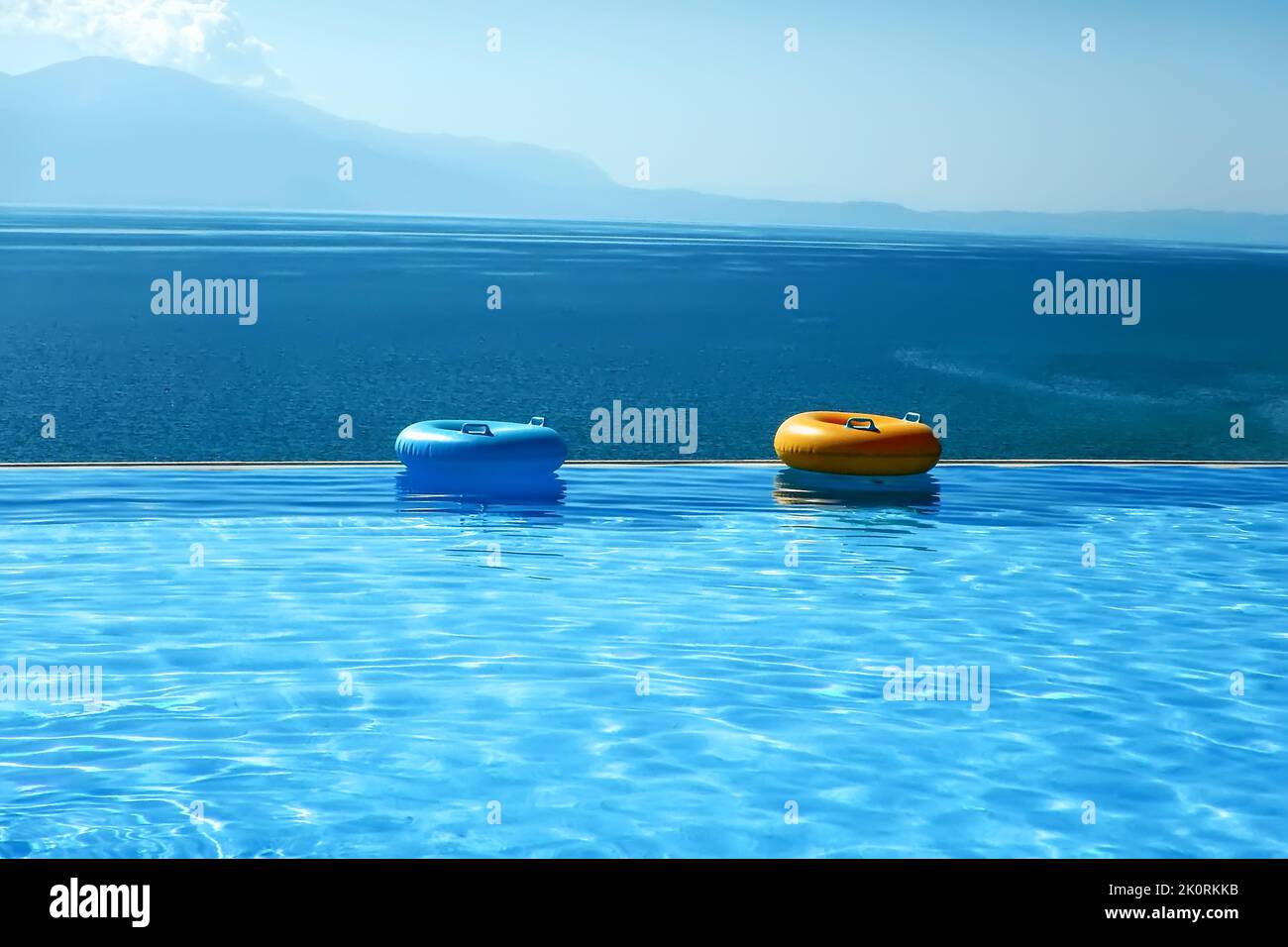 Infinity swimming pool with sea and Mountain View, float Stock Photo ...