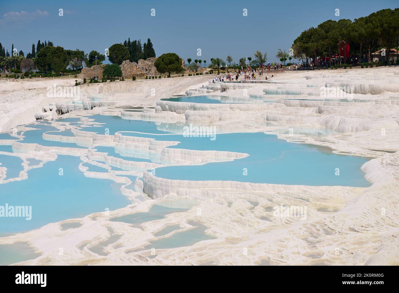 blue pools with water and white travertine terraces of Pamukkale ...