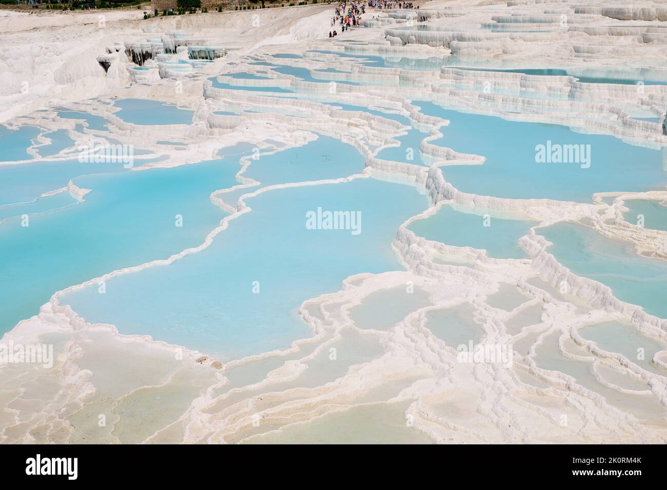blue pools with water and white travertine terraces of Pamukkale ...
