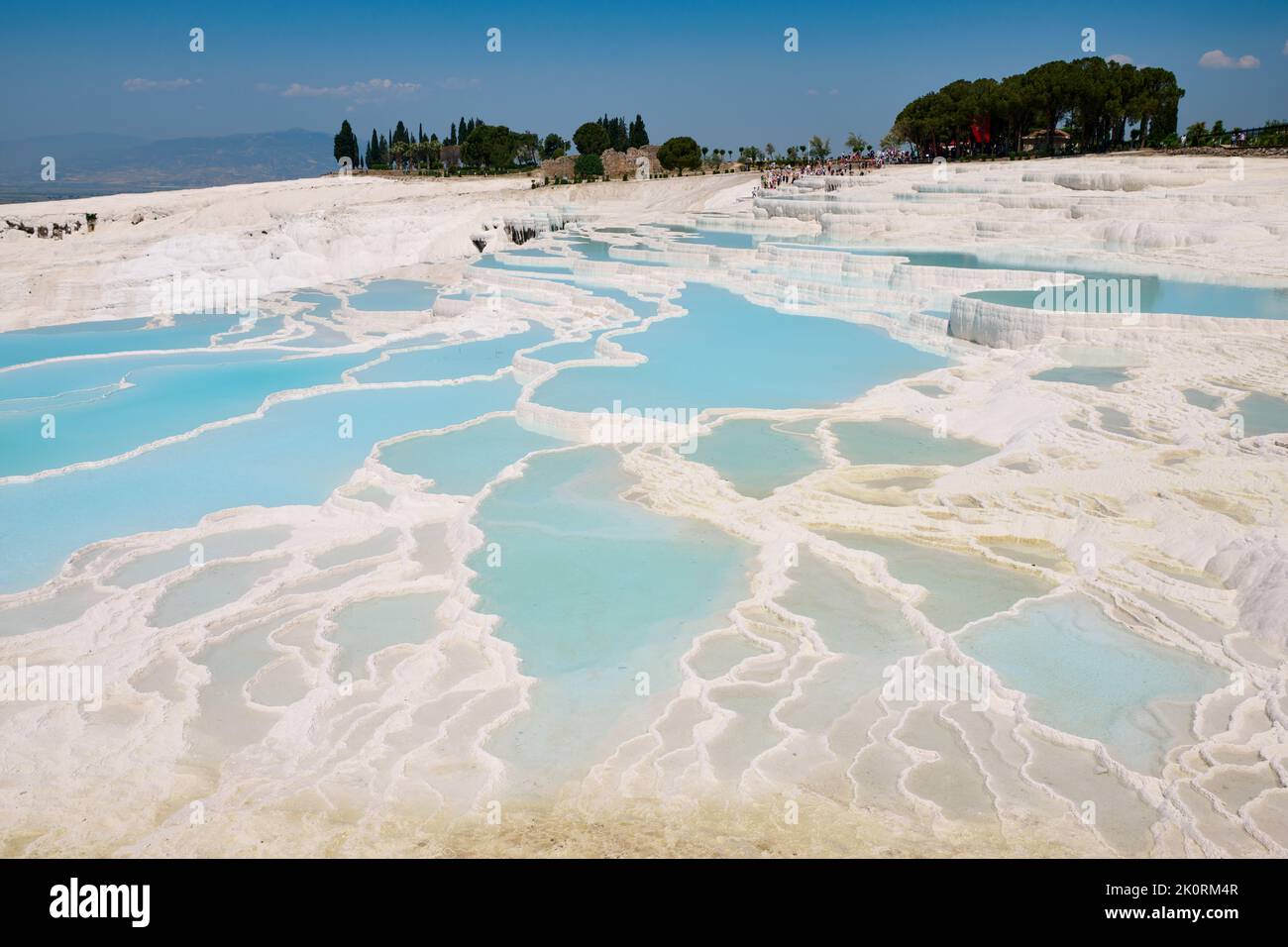 blue pools with water and white travertine terraces of Pamukkale ...