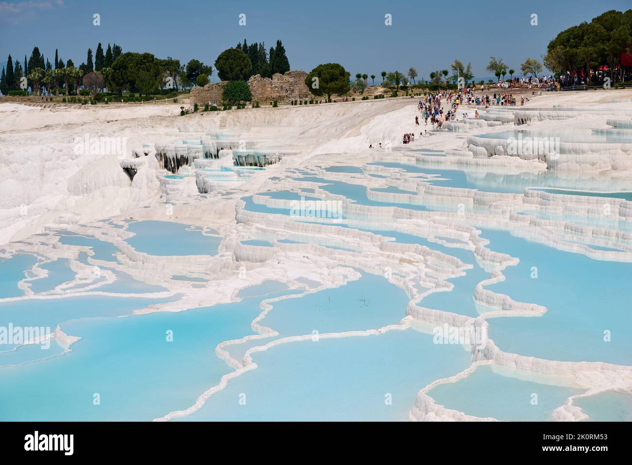 blue pools with water and white travertine terraces of Pamukkale ...